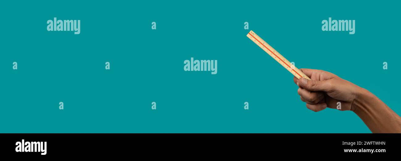 Black male hand holding a vintage or antique ruler isolated on ...