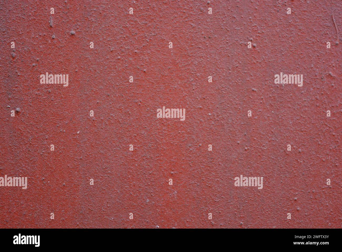 An old, uneven, metal surface with bumps covered with brown, red ...