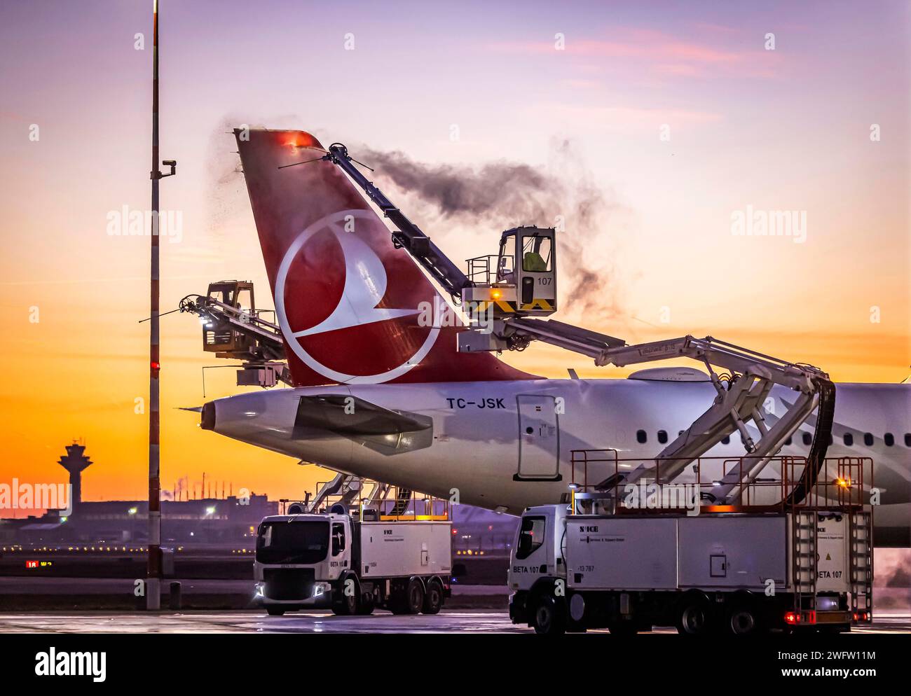 Frost at the airport, a Turkish Airlines aircraft is de-iced in front ...