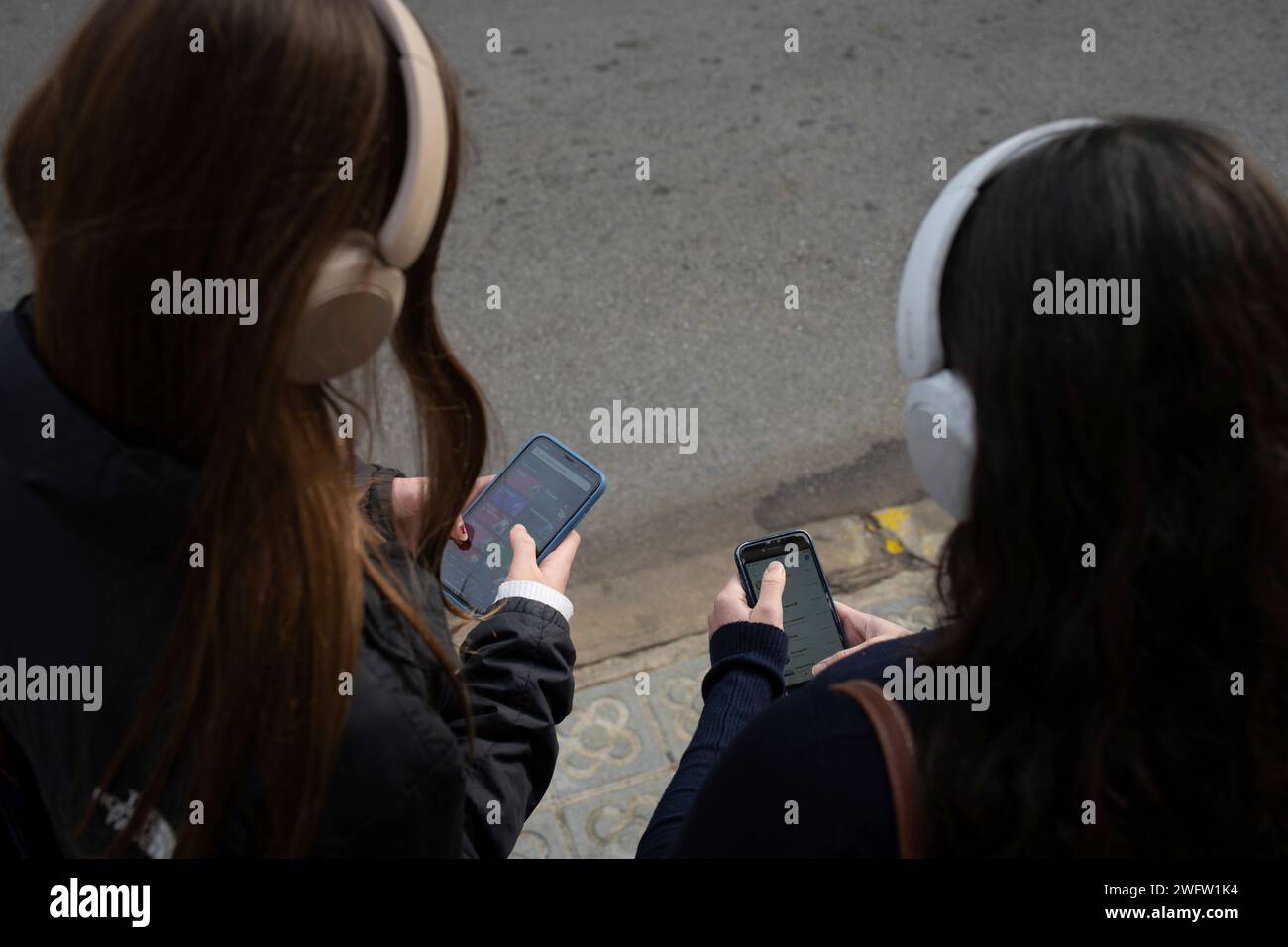 Two people use cell phones on February 1, 2024, in Barcelona, Catalonia ...