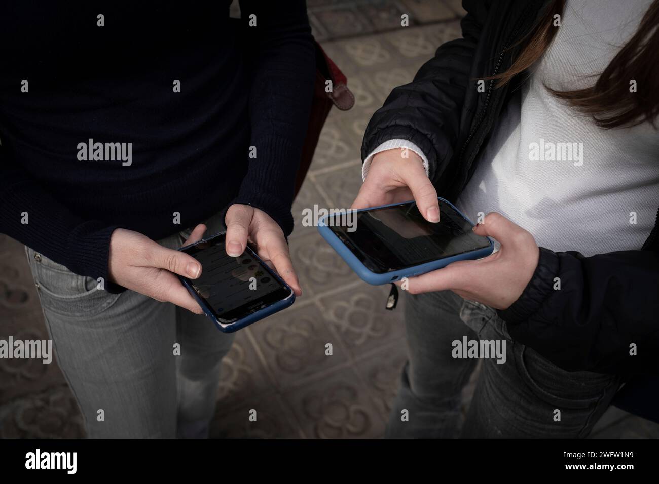 Two people use cell phones on February 1, 2024, in Barcelona, Catalonia ...