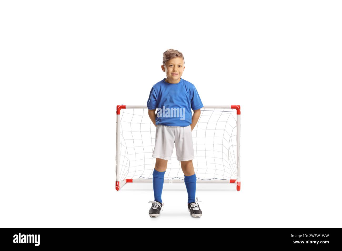 Boy in a blue and white football kit standing in front of a goal ...