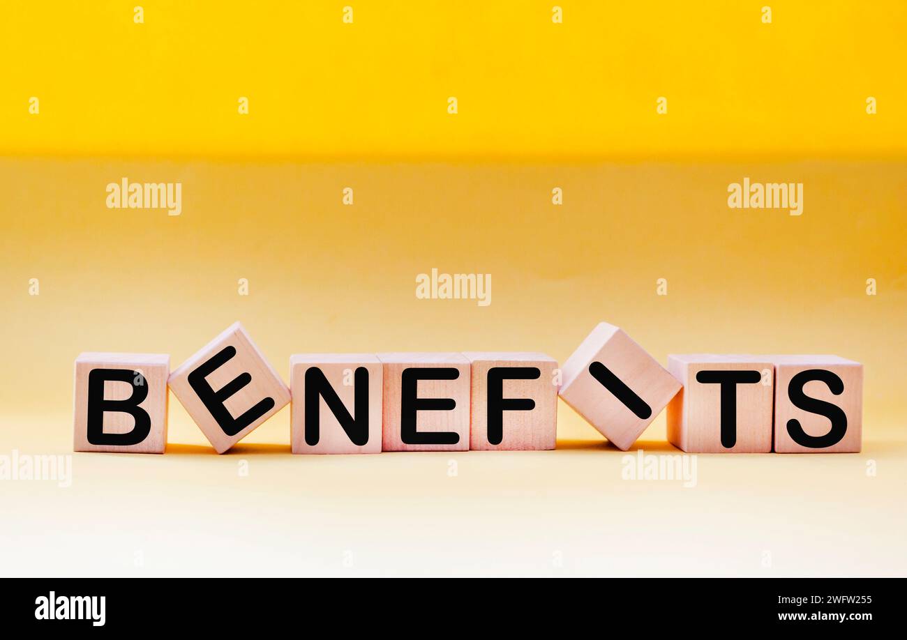 Benefits word on wooden blocks on a beautiful yellow background. Copy ...