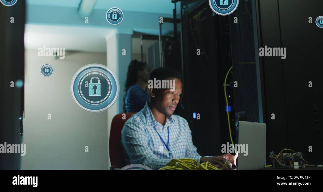 Image of digital padlocks over african american man working on laptop ...