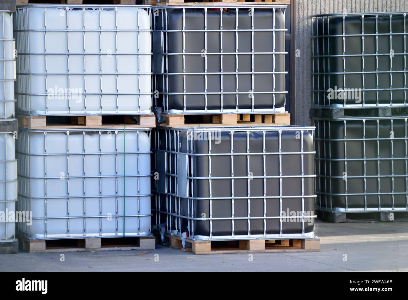 A stack of freight containers in rows at the factory with liquid inside ...