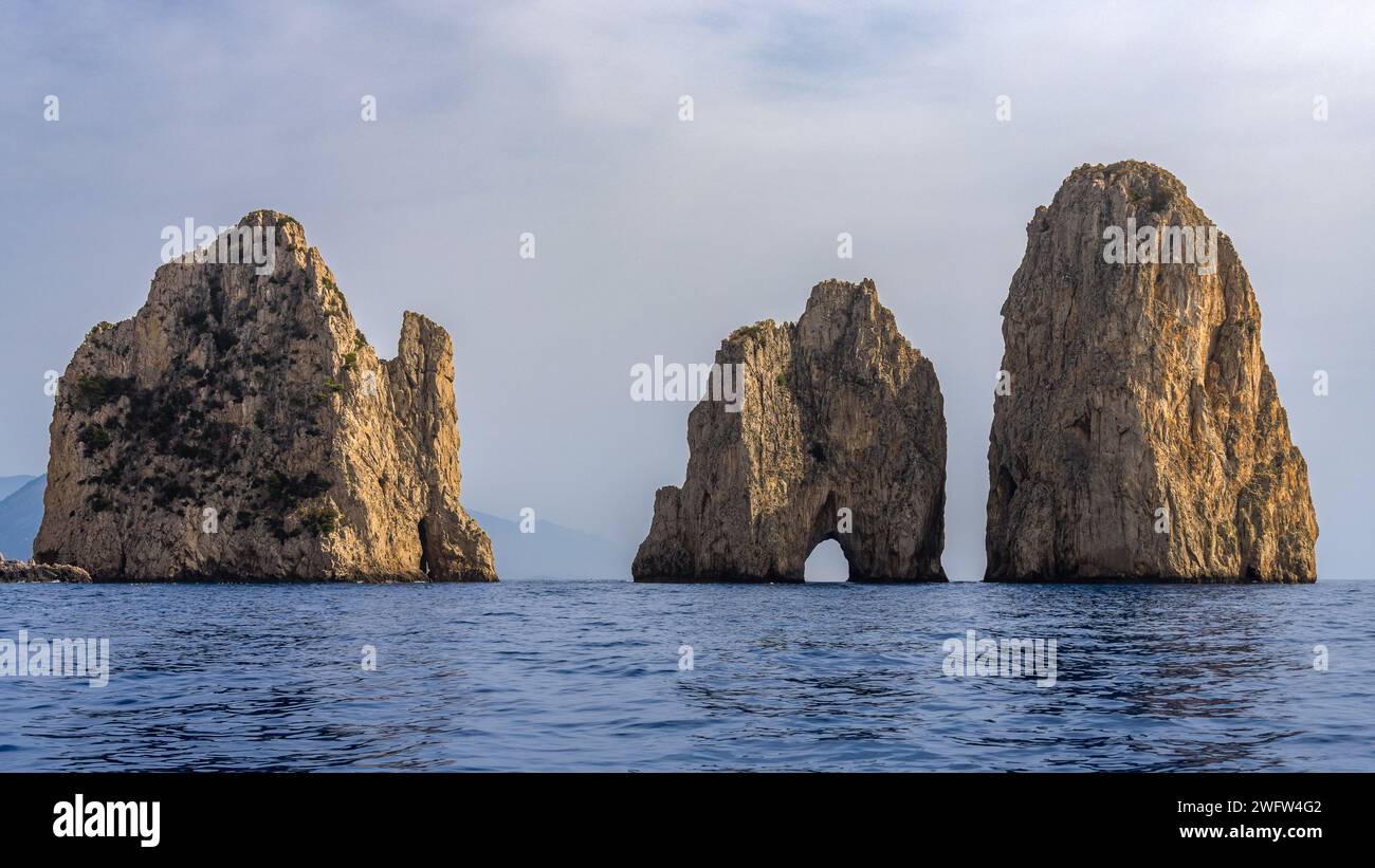 Some sea stacks rise from the ocean, surrounded by water and a scenic ...