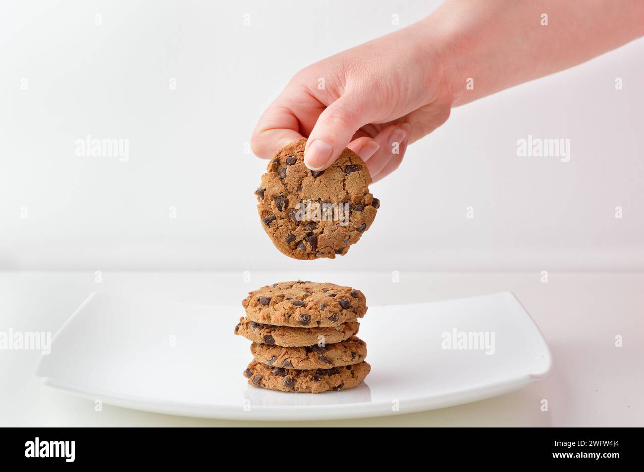 Hand holding chocolate chip cookie hi-res stock photography and images ...