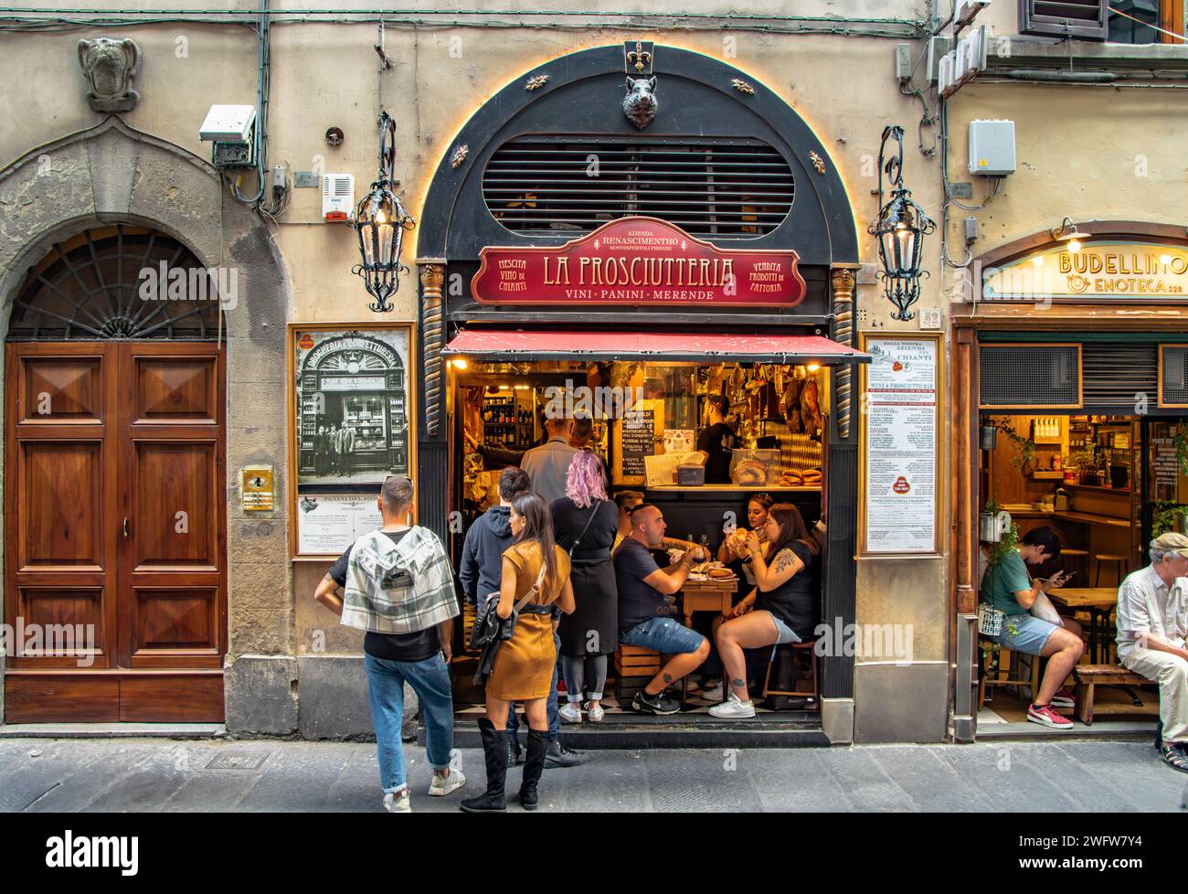People sitting down eating sandwiches at La Prosciutteria di Firenze ,a ...