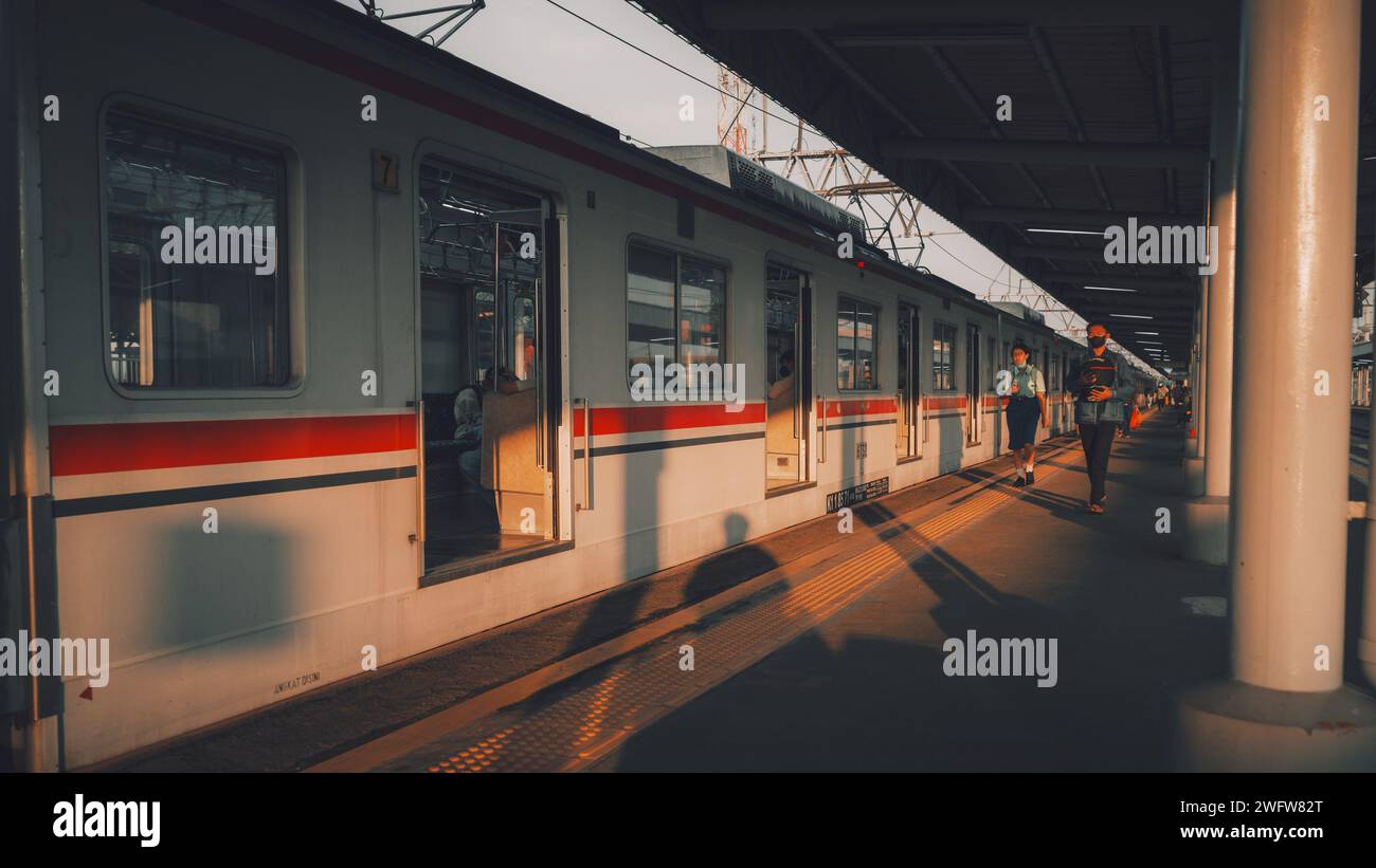 People walking in the train station platform beside the stopping train ...