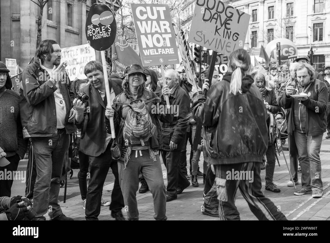 Lively street scene with people carrying placards in protest march on ...