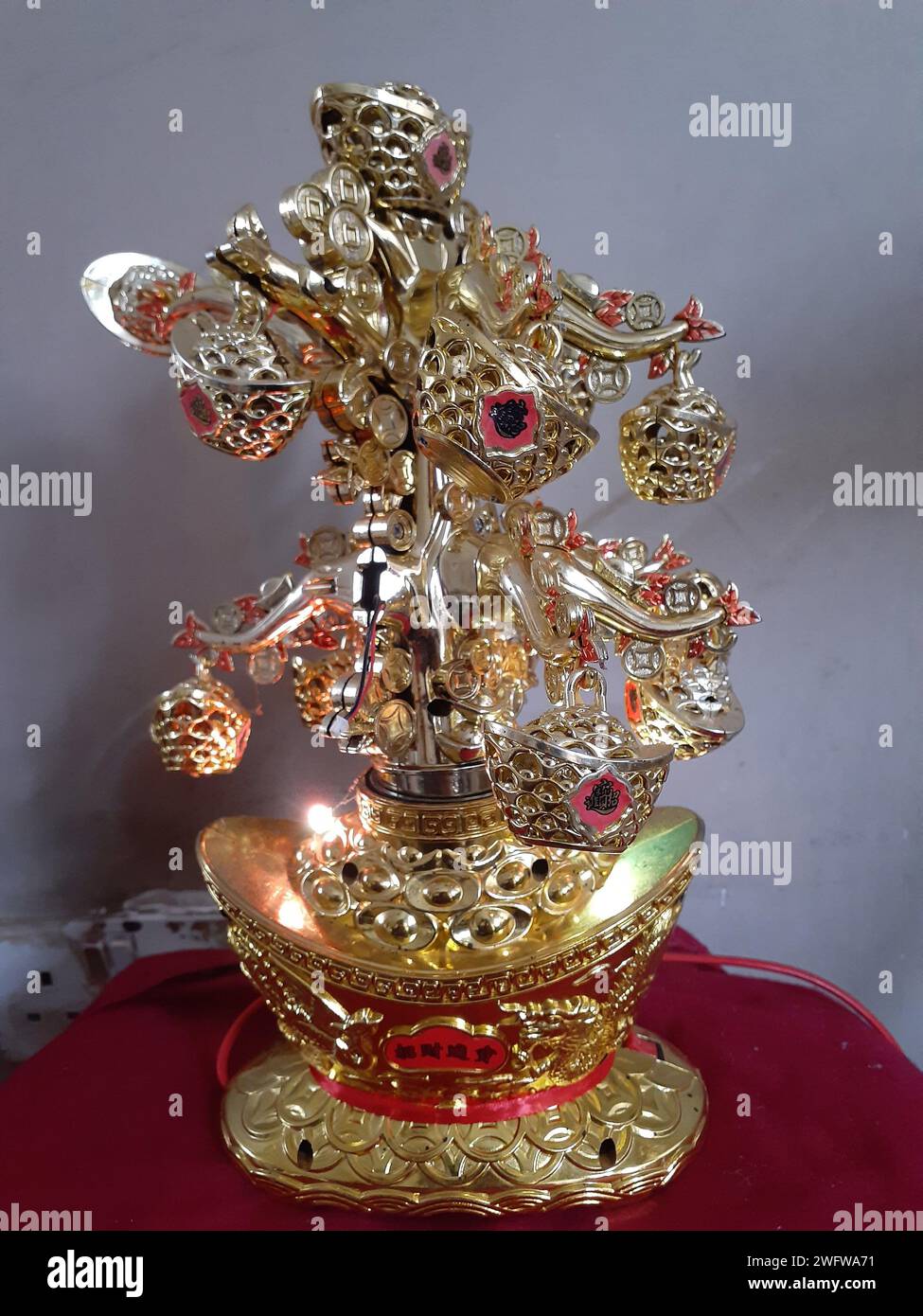 Intricate golden statue showcased against a grey wall Stock Photo - Alamy