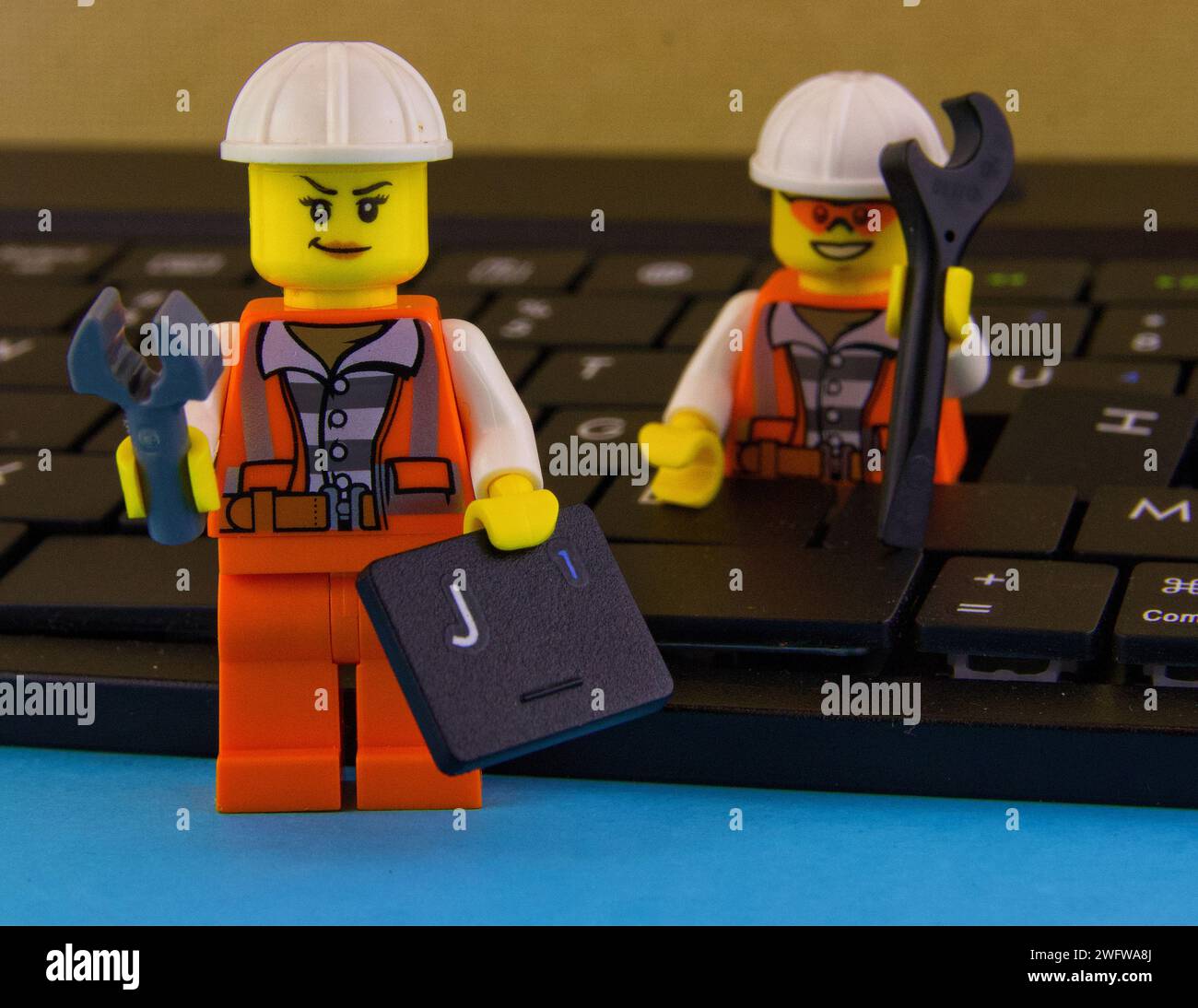 A toy minifigure working on qwerty computer keyboard with tools Stock ...
