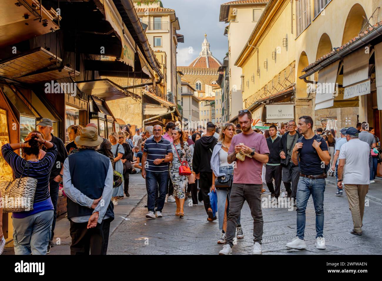 Crowds of people walking on the Ponte Vecchio bridge browsing the many ...