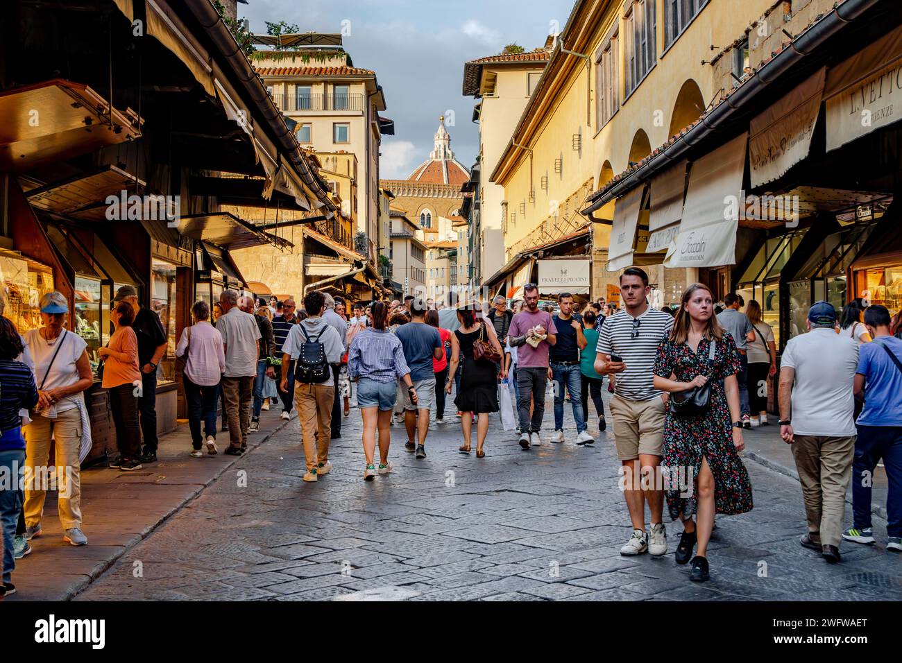 Crowds of people walking on the Ponte Vecchio bridge browsing the many ...