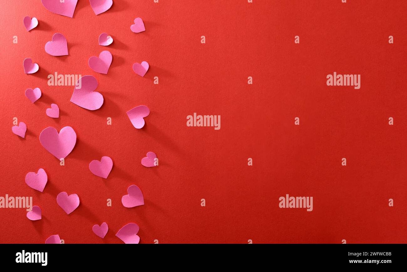 Love background with fuxia pink heart cutouts of various sizes on the ...