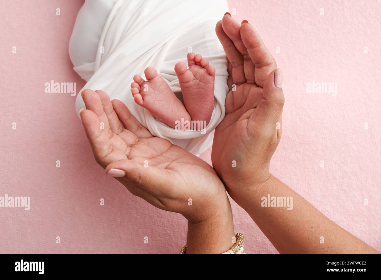 The palms of father, the mother are holding foot of the newborn baby in ...