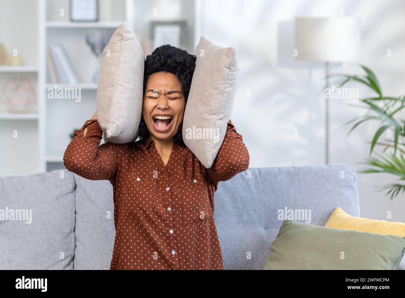 Close-up photo of a young African-American woman sitting on the couch ...