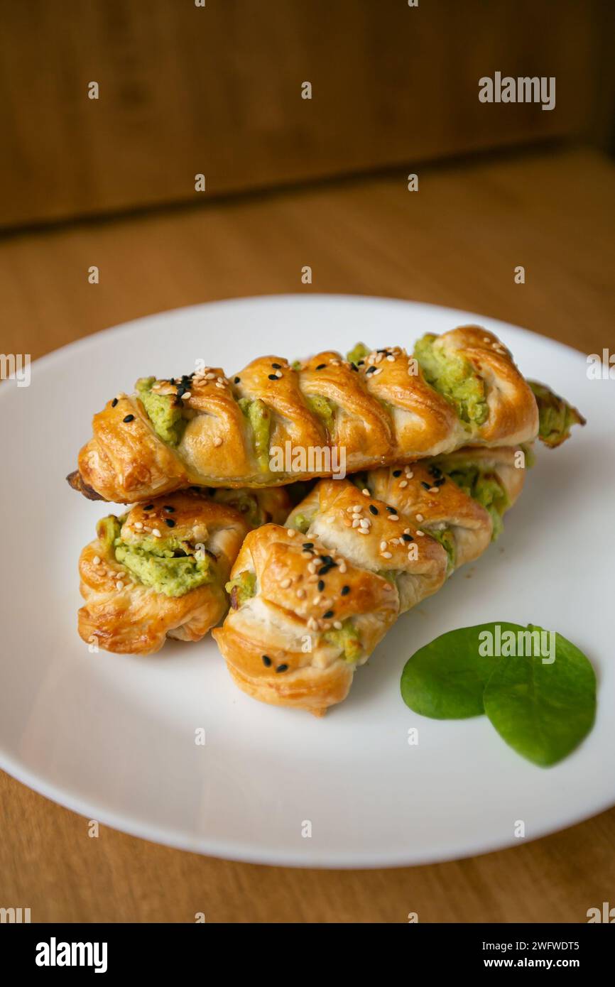 Turkish borek rolls with spinach and cheese on the white plate. A ...
