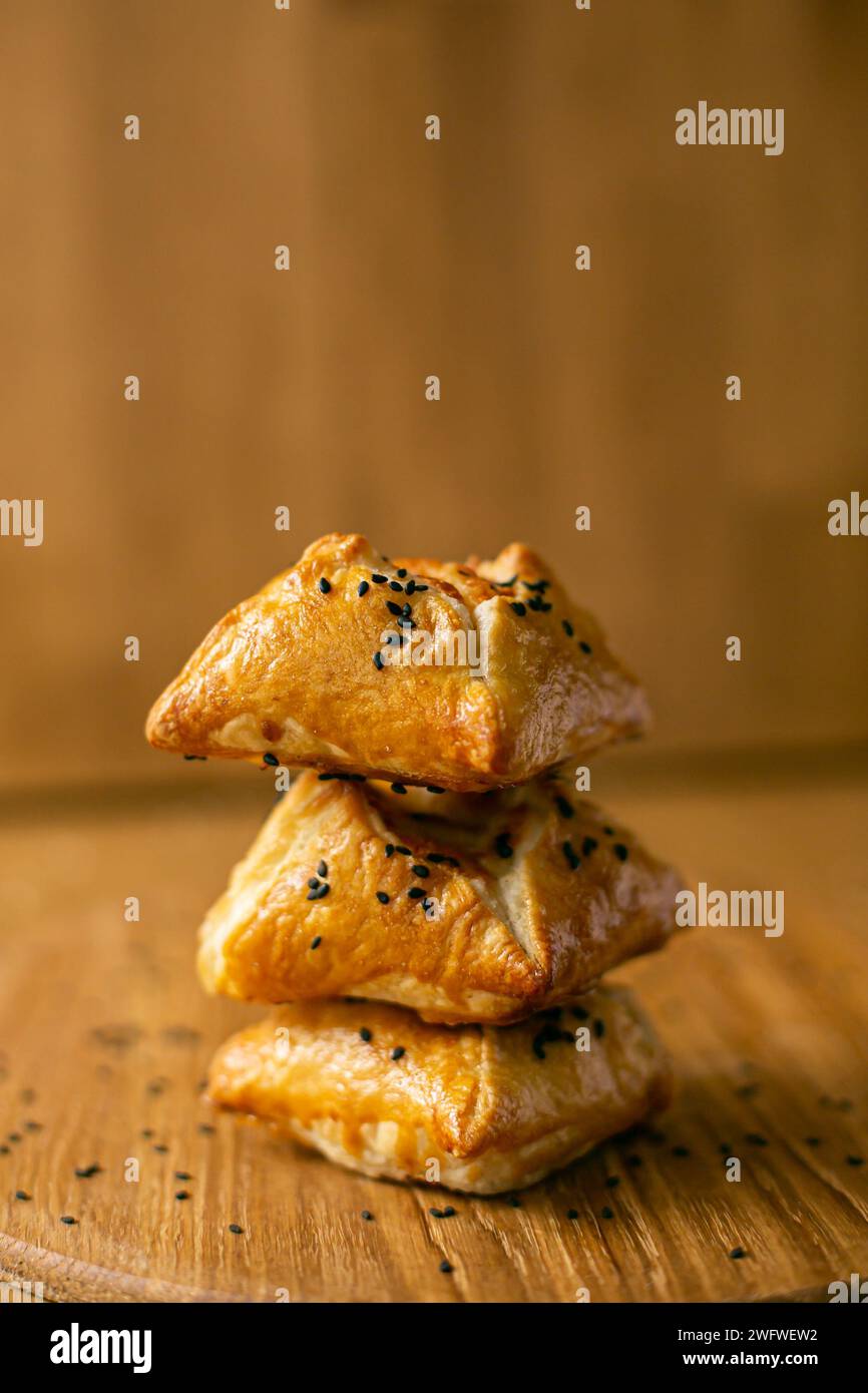 four edible square puff pastry baskets with chiken on a white round ...