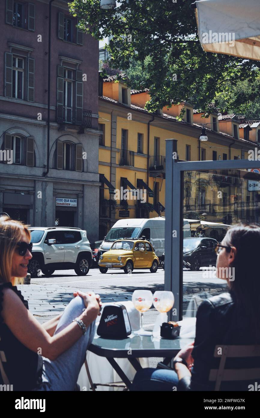 girls having a drink and mini cooper car in the background in the ...