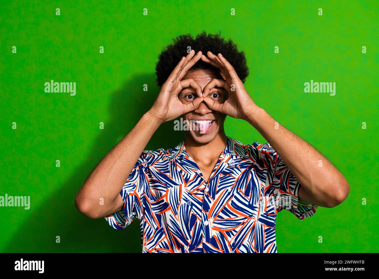 Photo of young stupid guy joking made fingers okey sign binoculars ...