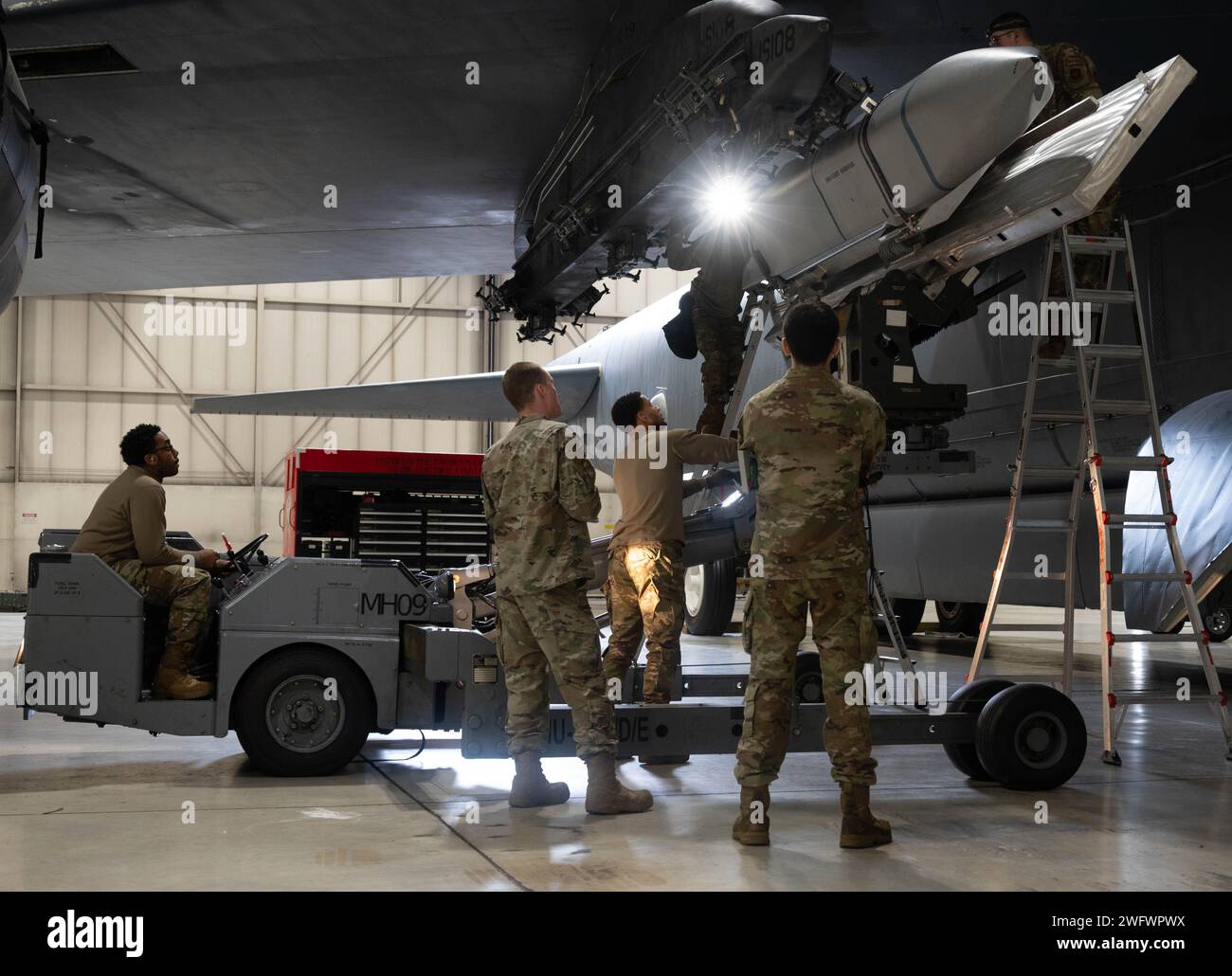 Airmen assigned to the 5th Aircraft Maintenance Squadron load an inert ...