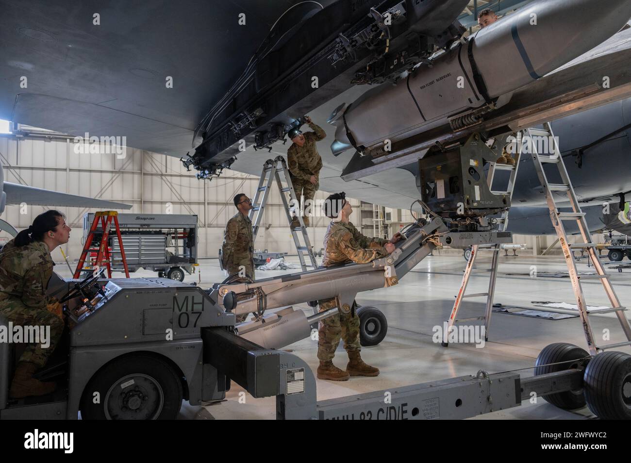Members of the 5th Aircraft Maintenance Squadron load an inert AGM-158 ...