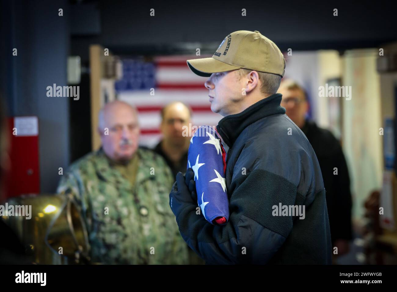 U.S. Navy Reserve Yeoman 2nd Class Mathew West cradles the U.S. flag ...