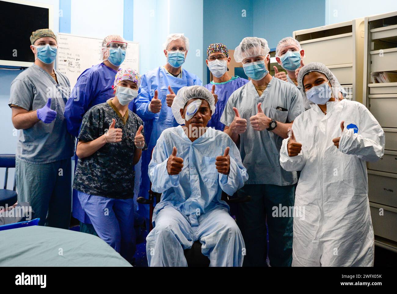 U.S. Navy Sailors pose for a group photo with a Chuukese patient and ...