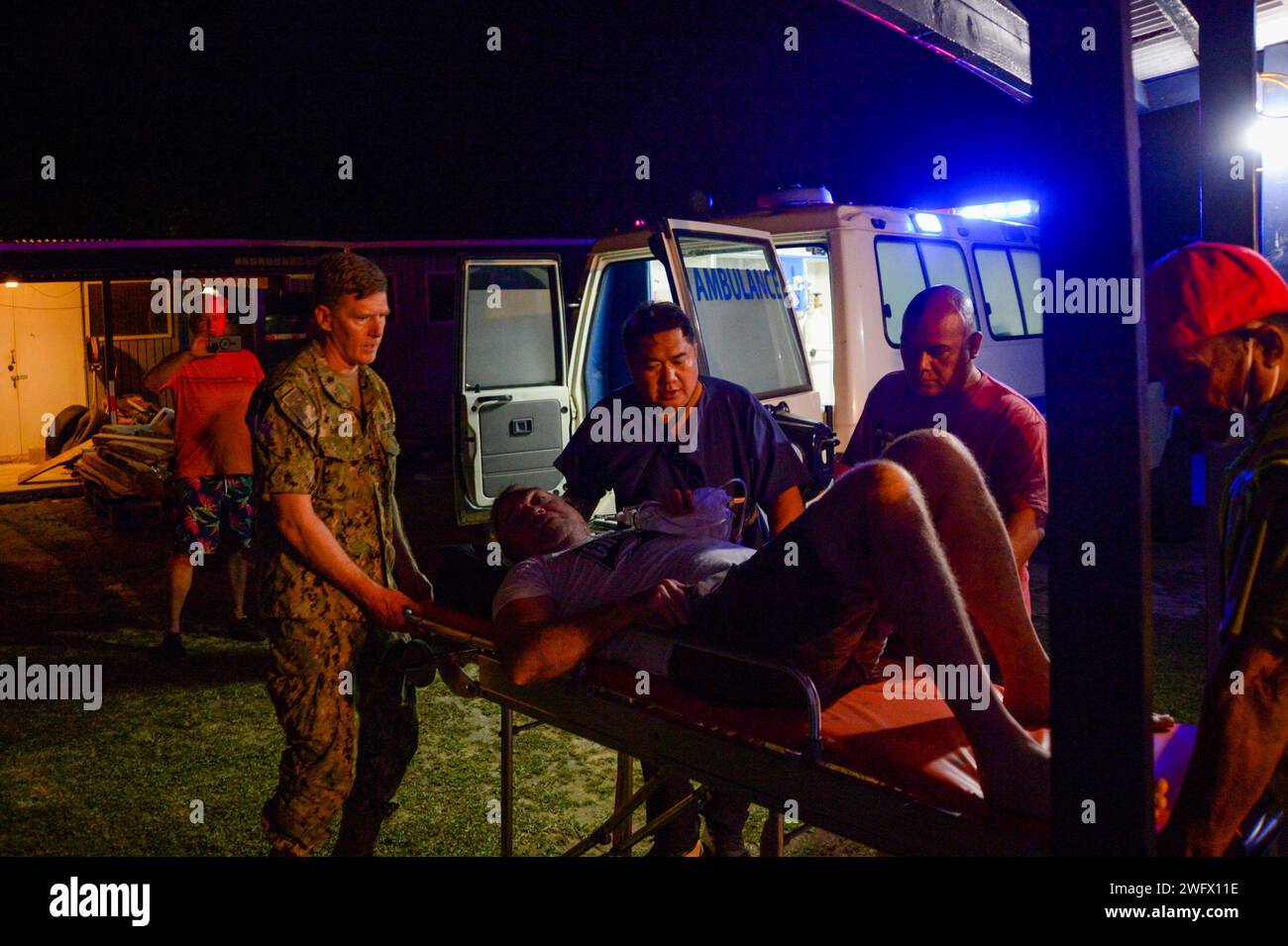 U.S. Navy Capt. Daniel Switlick, left, helps local Micronesian care ...