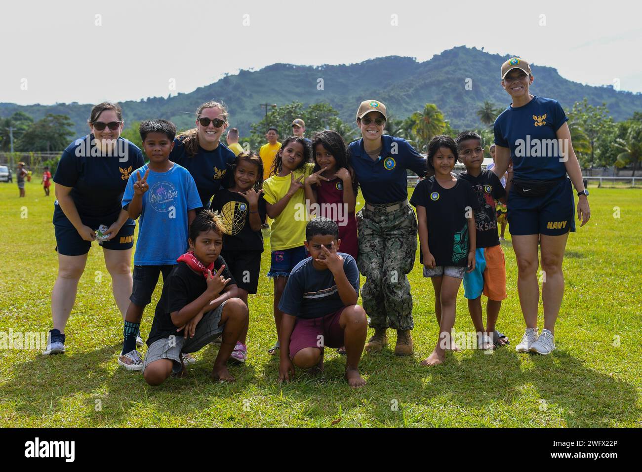 U.S. Navy Sailors pose for a group photo with local children at ...