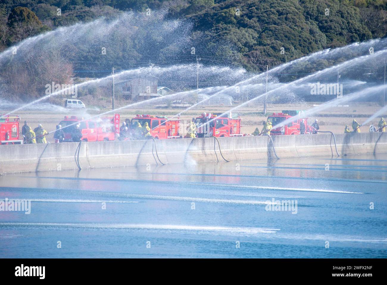 Firefighters from the Saikai City Fire Department perform a fire hose ...