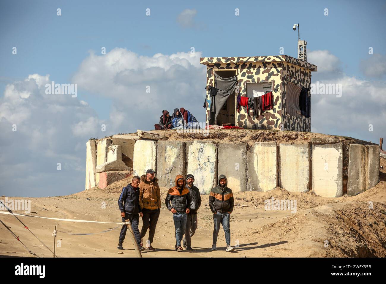 Rafah, Gaza. 30th Jan, 2024. Women sit by clothes drying on a laundry ...