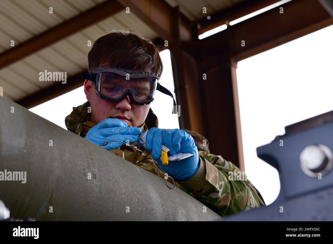 A U.S. Air Force Airman from the 57th Munitions Squadron applies a ...
