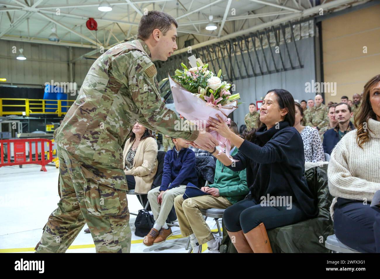 A U.S. Air Force Airman with the 177th Fighter Wing hands flowers to ...