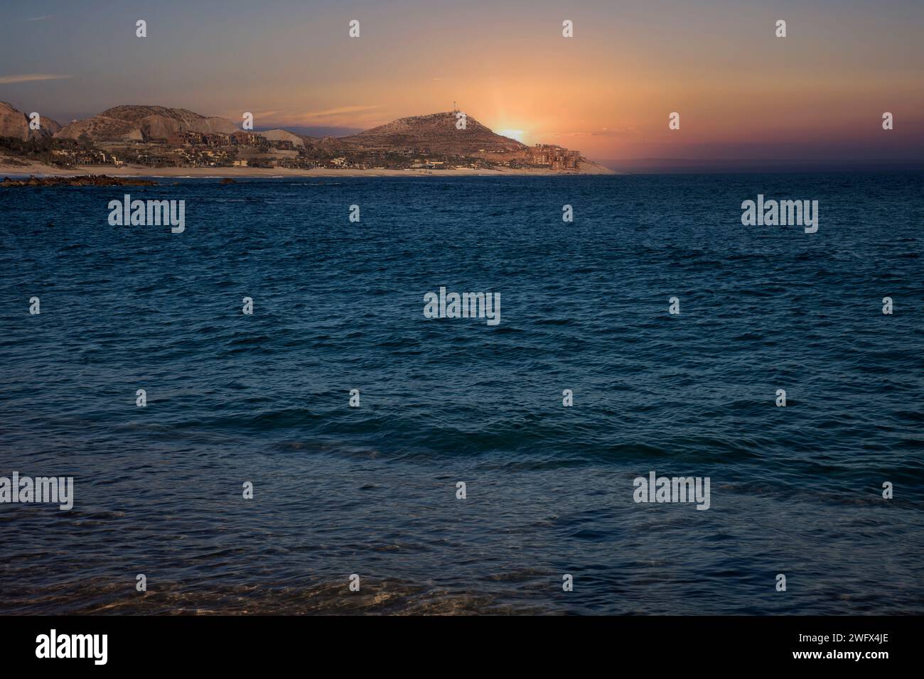 Sun setting over the sea and desert in Cabo San Lucas, Mexico Stock ...
