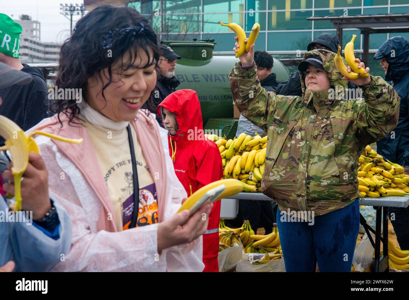 A volunteer hands out bananas to runners at the finish line during the ...
