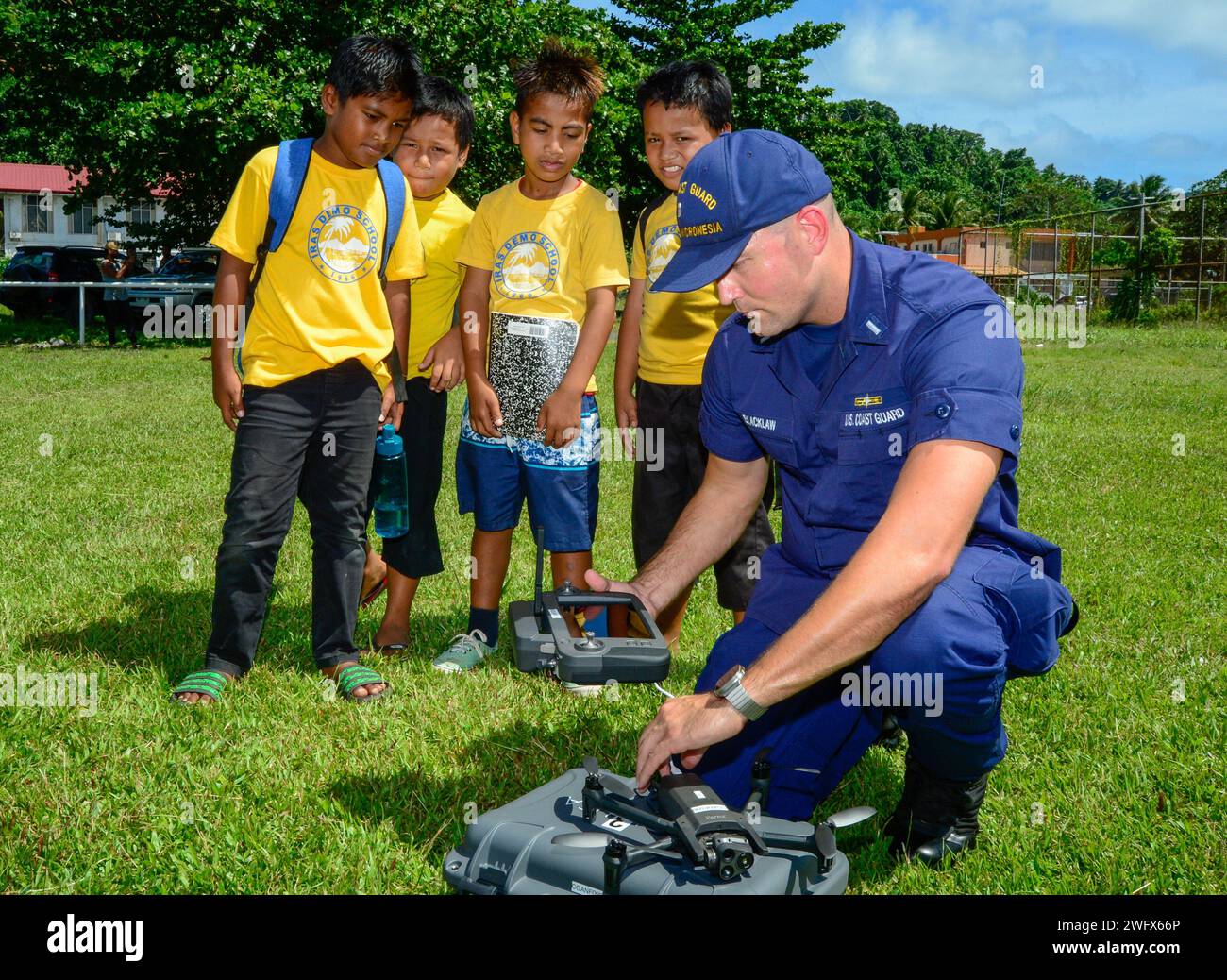 Chuukese children observe as U.S. Coast Guard Lt. j.g. Whip Blacklaw ...