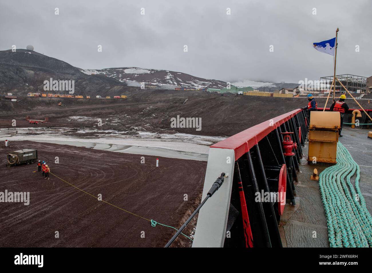 Several McMurdites pull in a heaving line attached to a mooring line ...