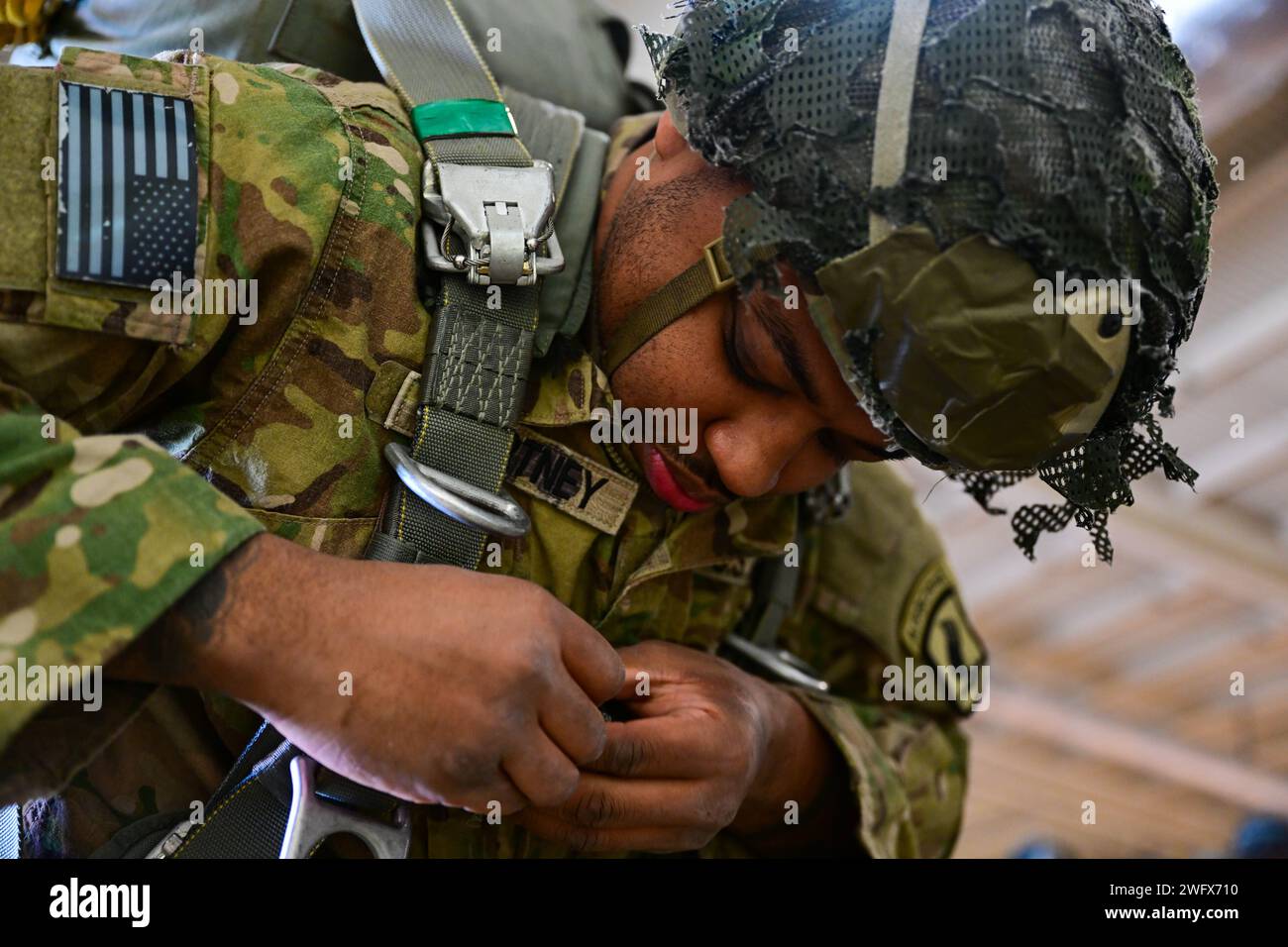 A U.S. Army Paratrooper assigned to the 173rd Airborne Brigade latches ...