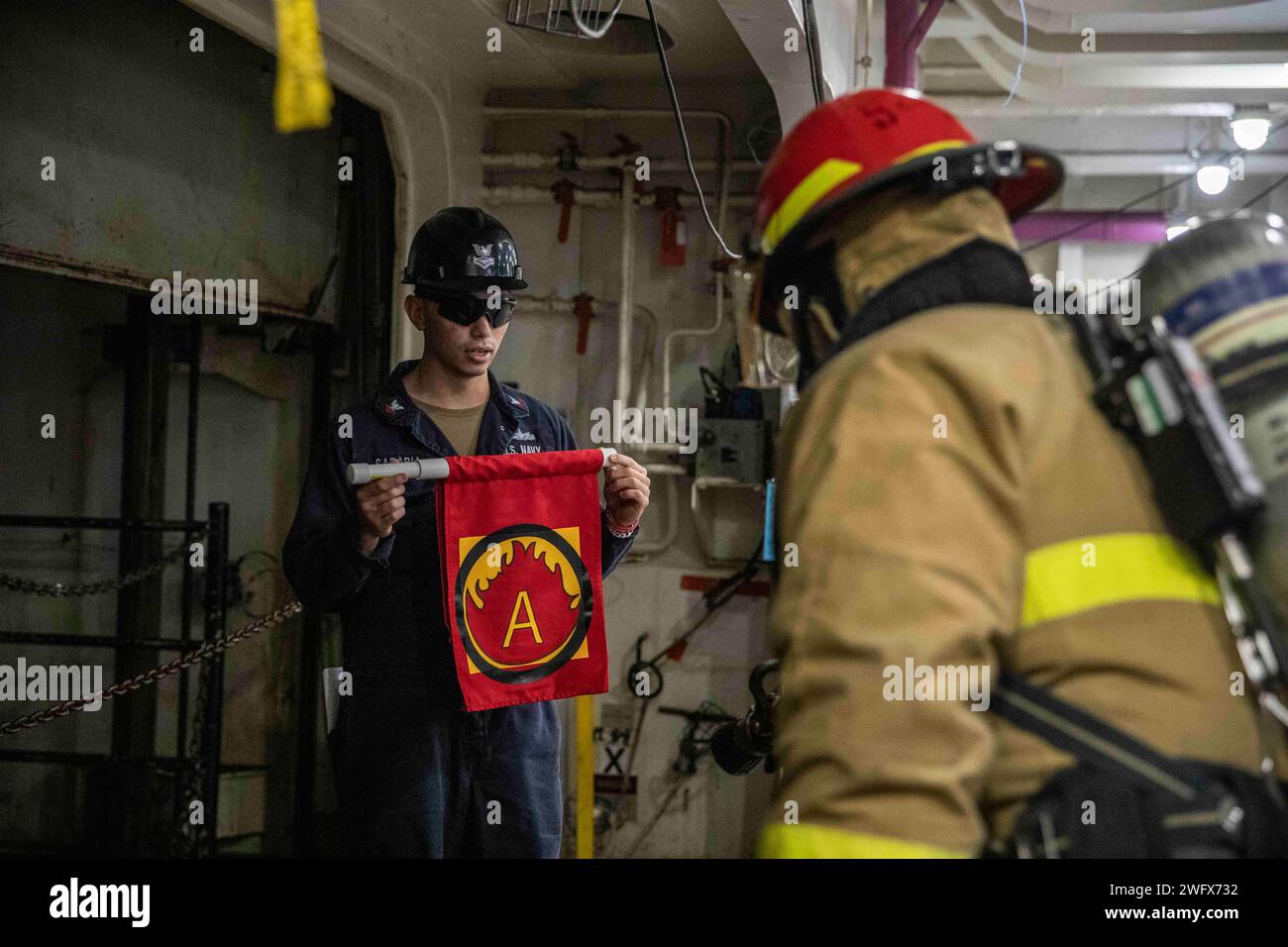 Damage Controlman 2nd Class Alexander Sarabia simulates a fire during a ...