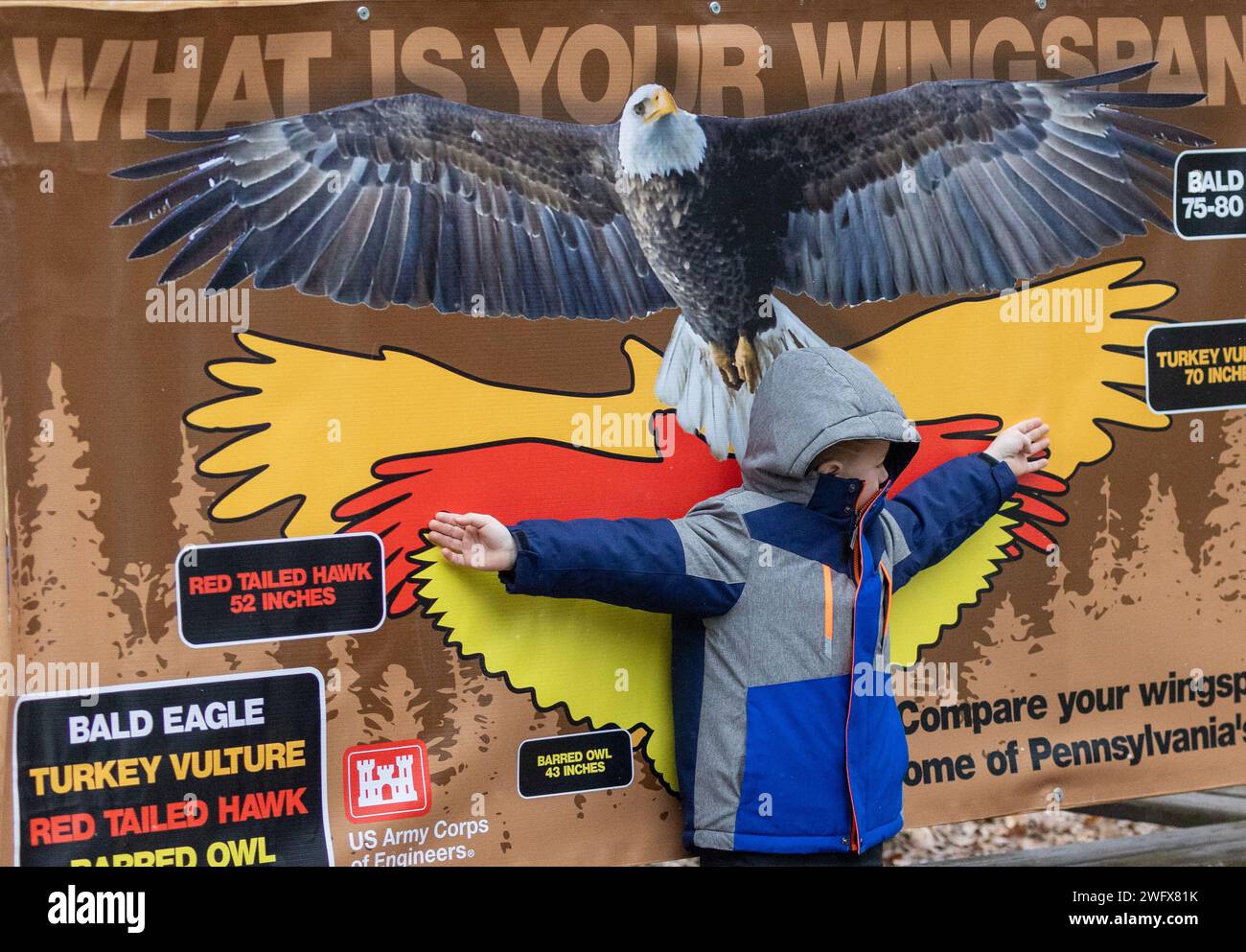 A young participant measures himself against a banner displaying the ...