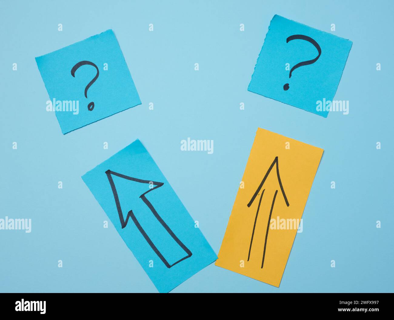 Paper sheets with drawn arrows and question marks, embodying the ...