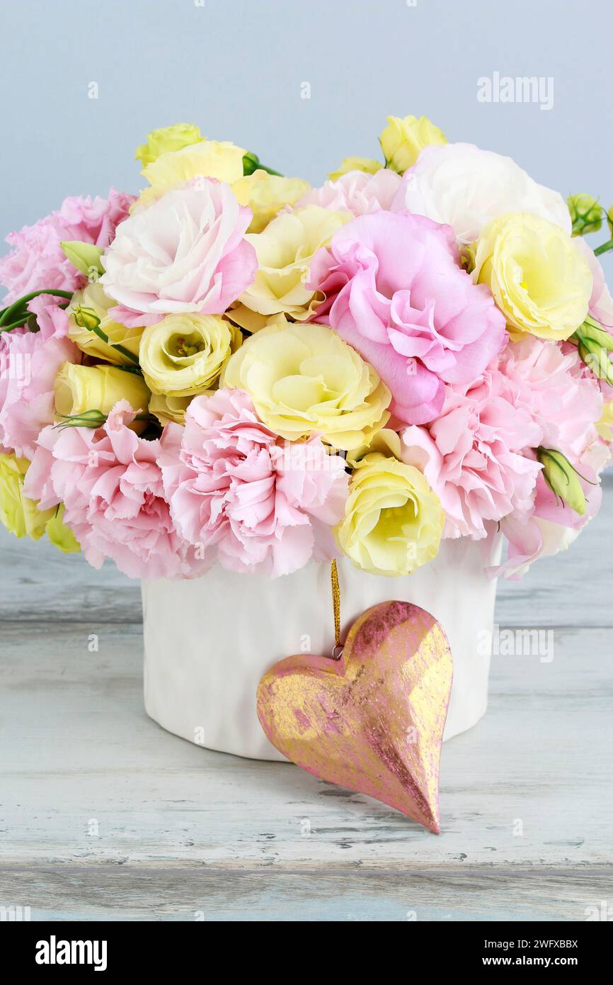 Floral arrangement with pink carnation and yellow eustoma flowers ...