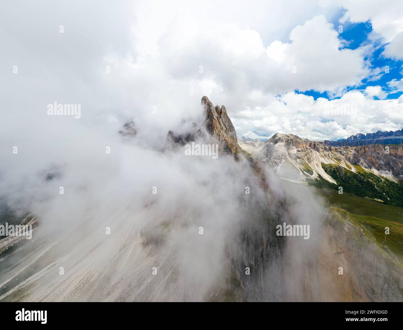 Dense fog covered rocky peak of Seceda mountain in touristic Italian ...