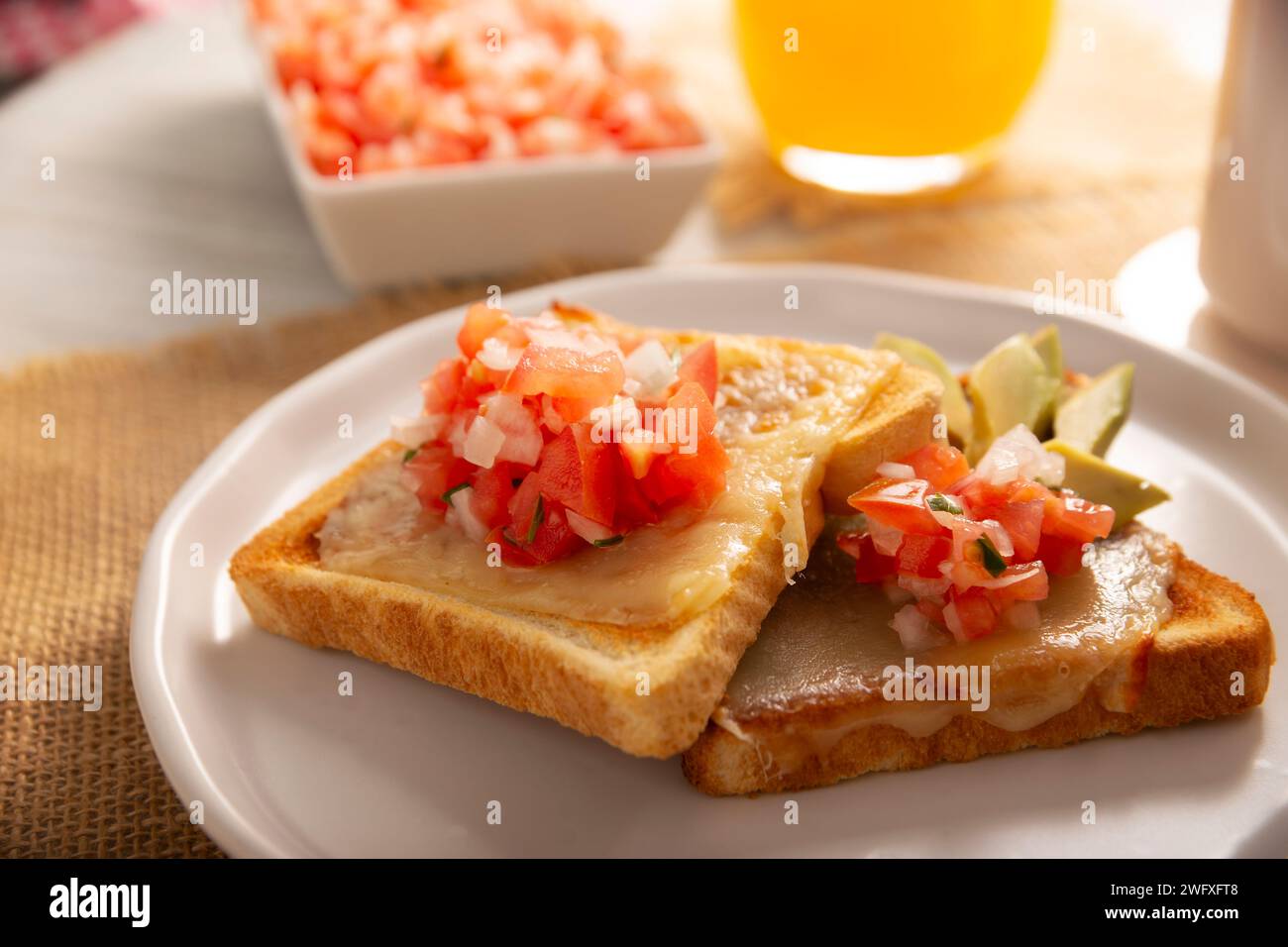 Breakfast toast with refried beans, avocado, melted cheese and mexican ...