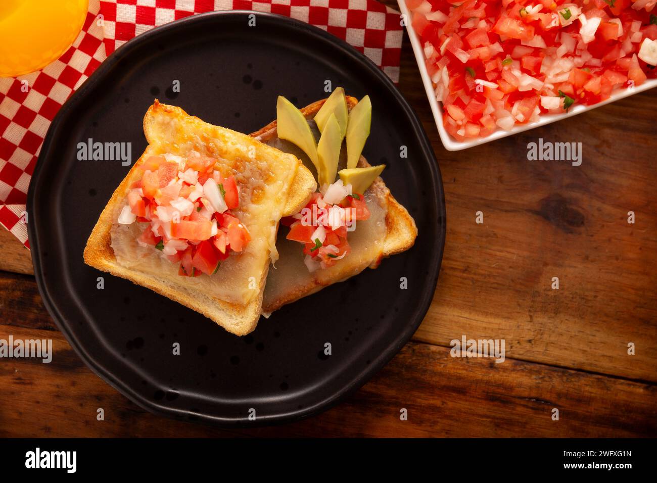 Breakfast toast with refried beans, avocado, melted cheese and mexican ...