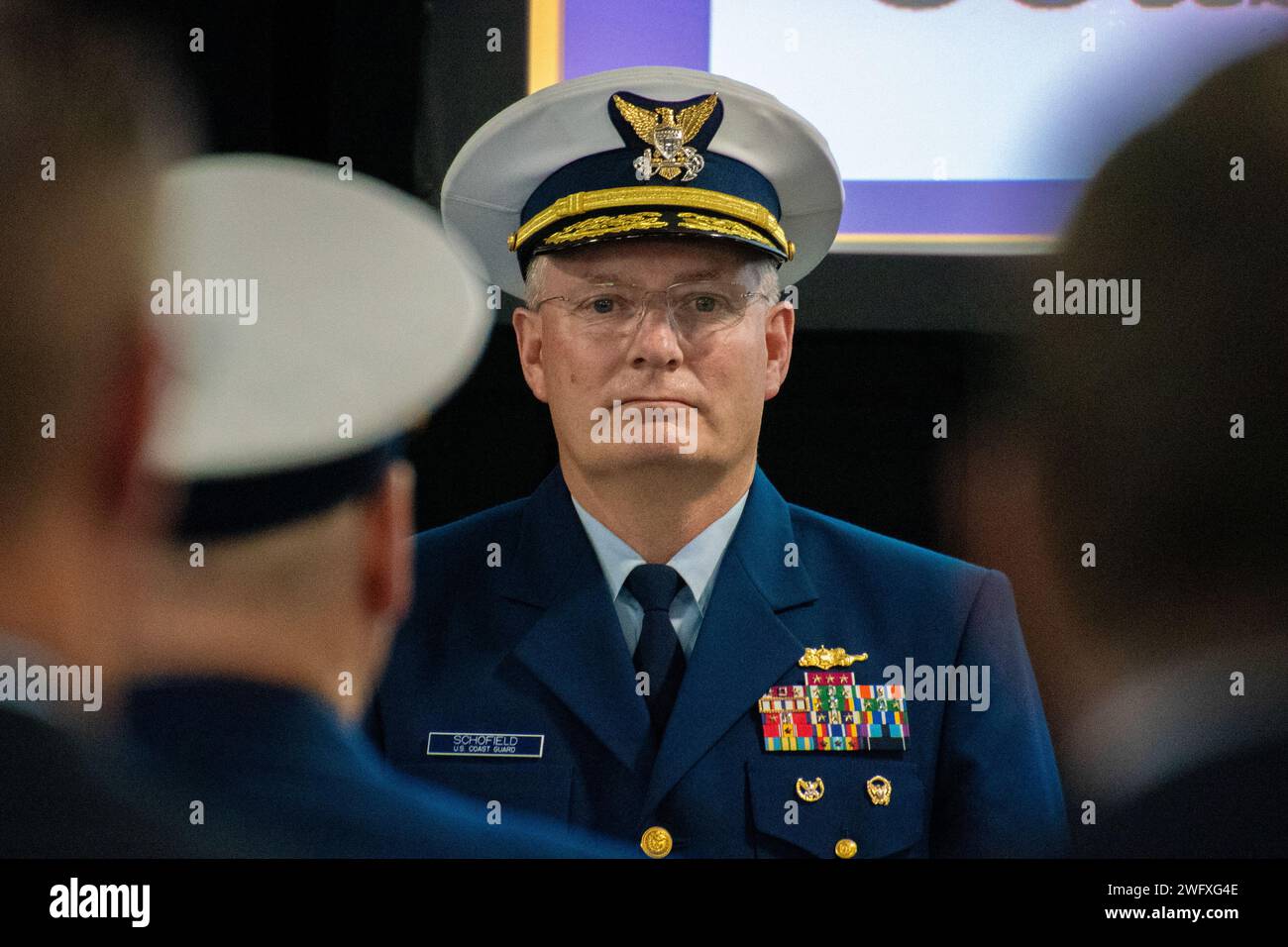 Rear Adm. Douglas Schofield, commander of Coast Guard District Seven, stands at attention during ...