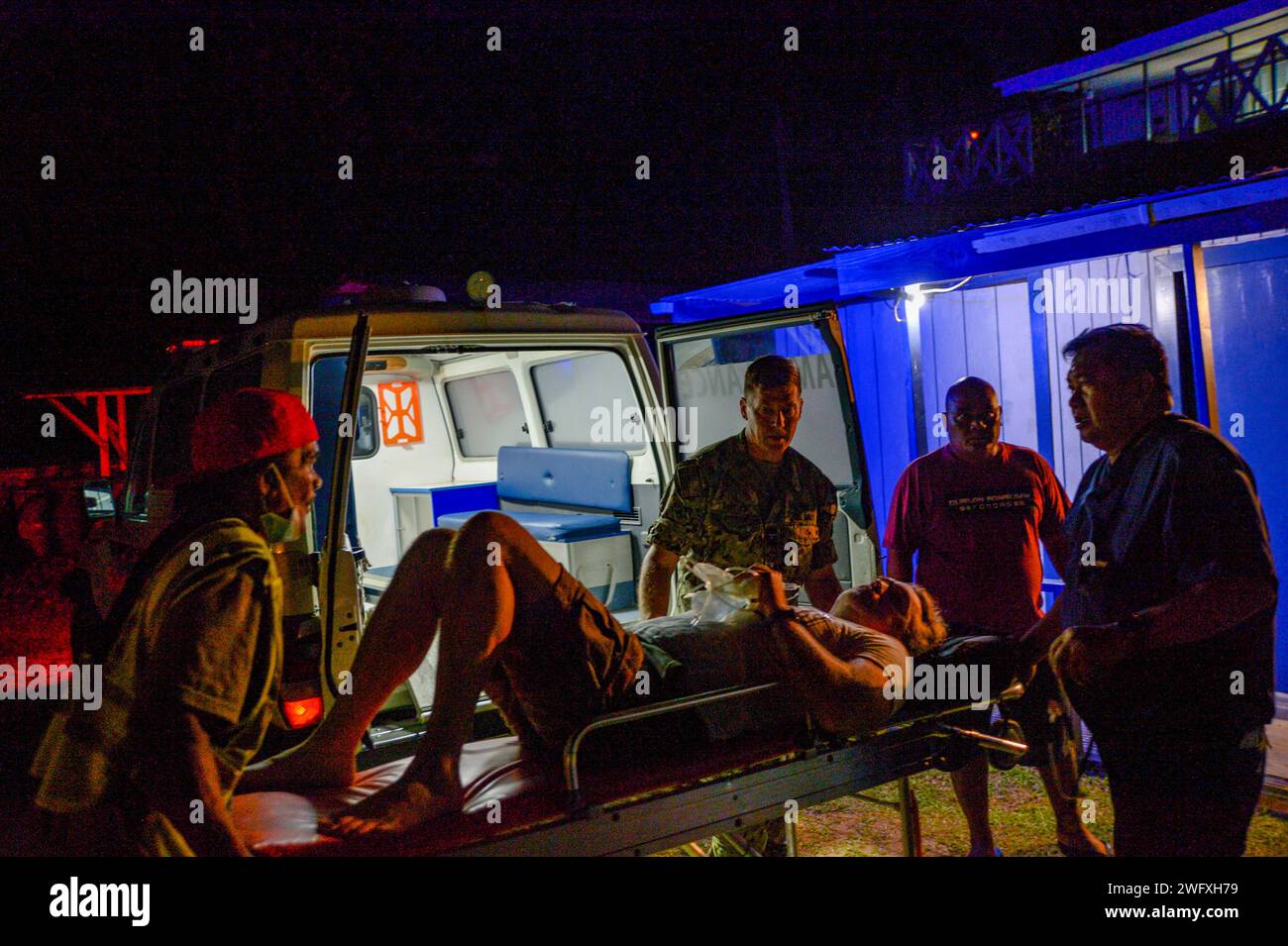 U.S. Navy Capt. Daniel Switlick, middle, helps local Micronesian care ...