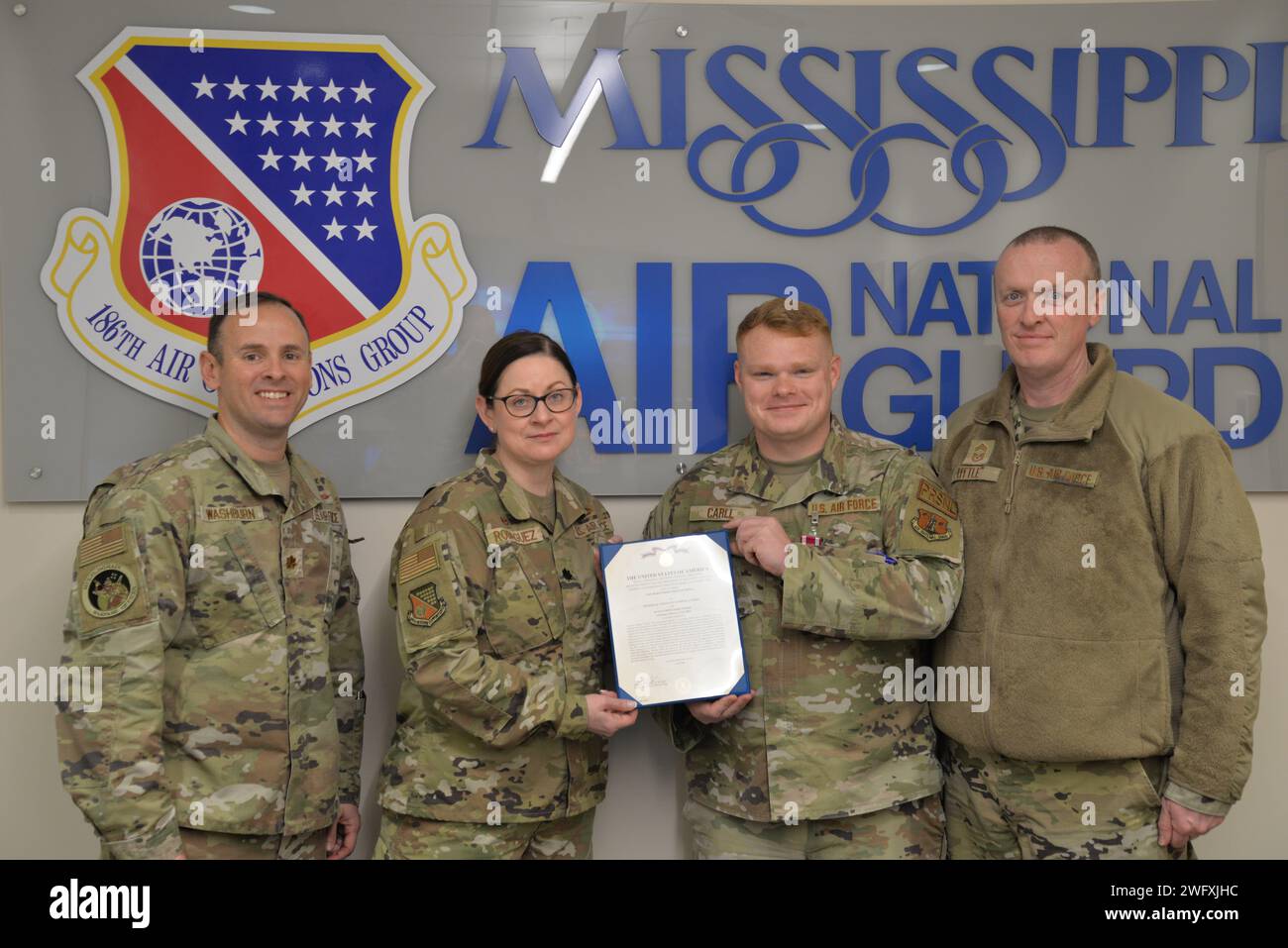Master Sgt. Patrick Carll (center right) receives the Meritorious ...